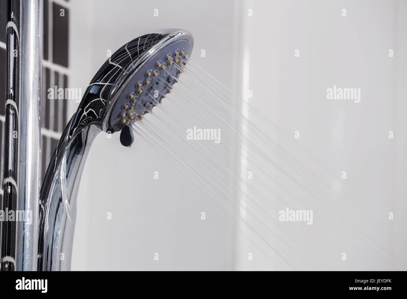 Tête de douche dans la salle de bains avec de l'eau gouttes coulant ...