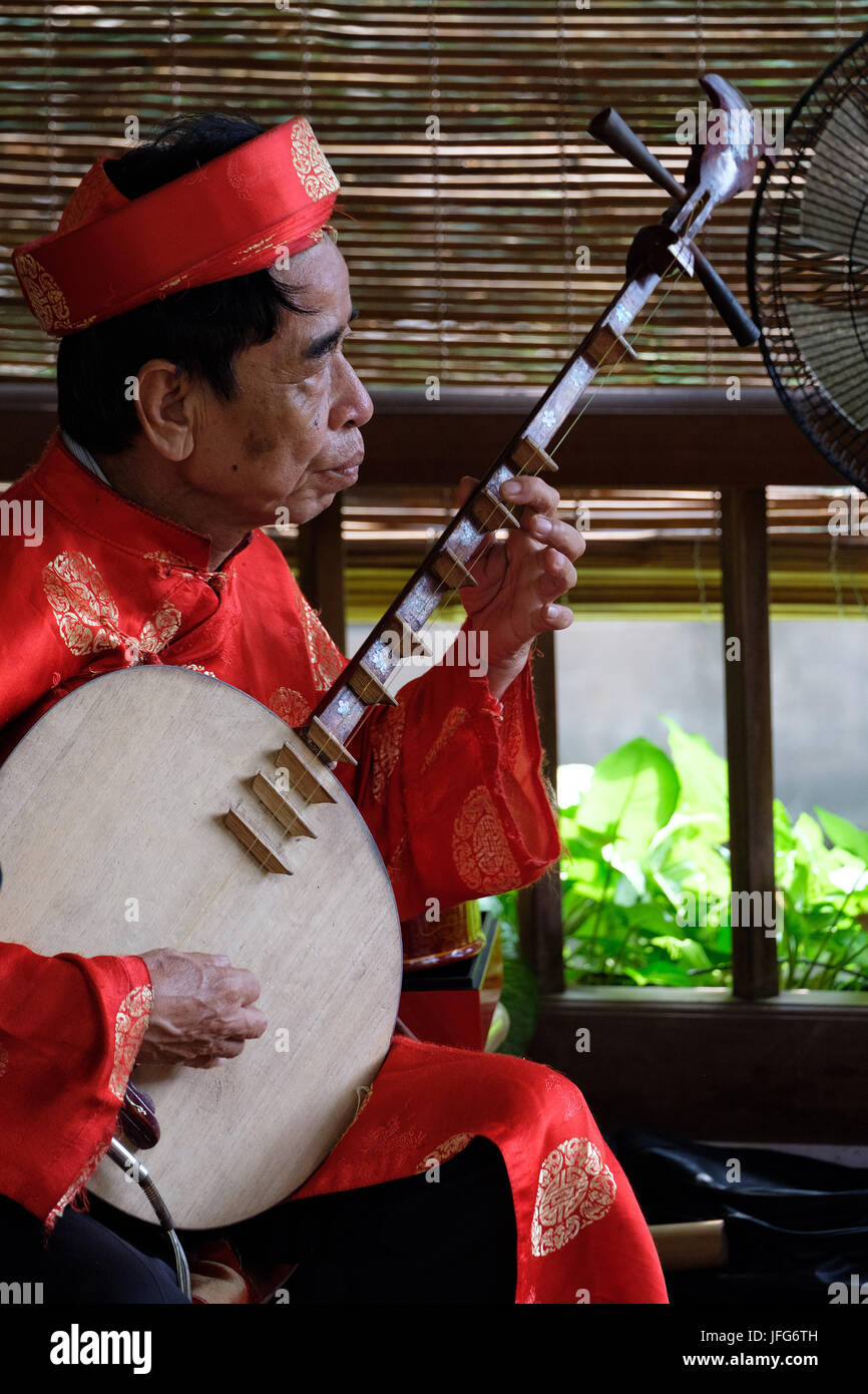 Vieil homme jouant d'un luth à deux cordes lune instrument de musique ...