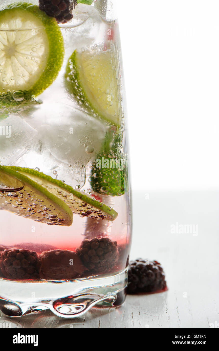 Cocktail gin tonic avec de la chaux, de la glace et aux fruits rouges ...