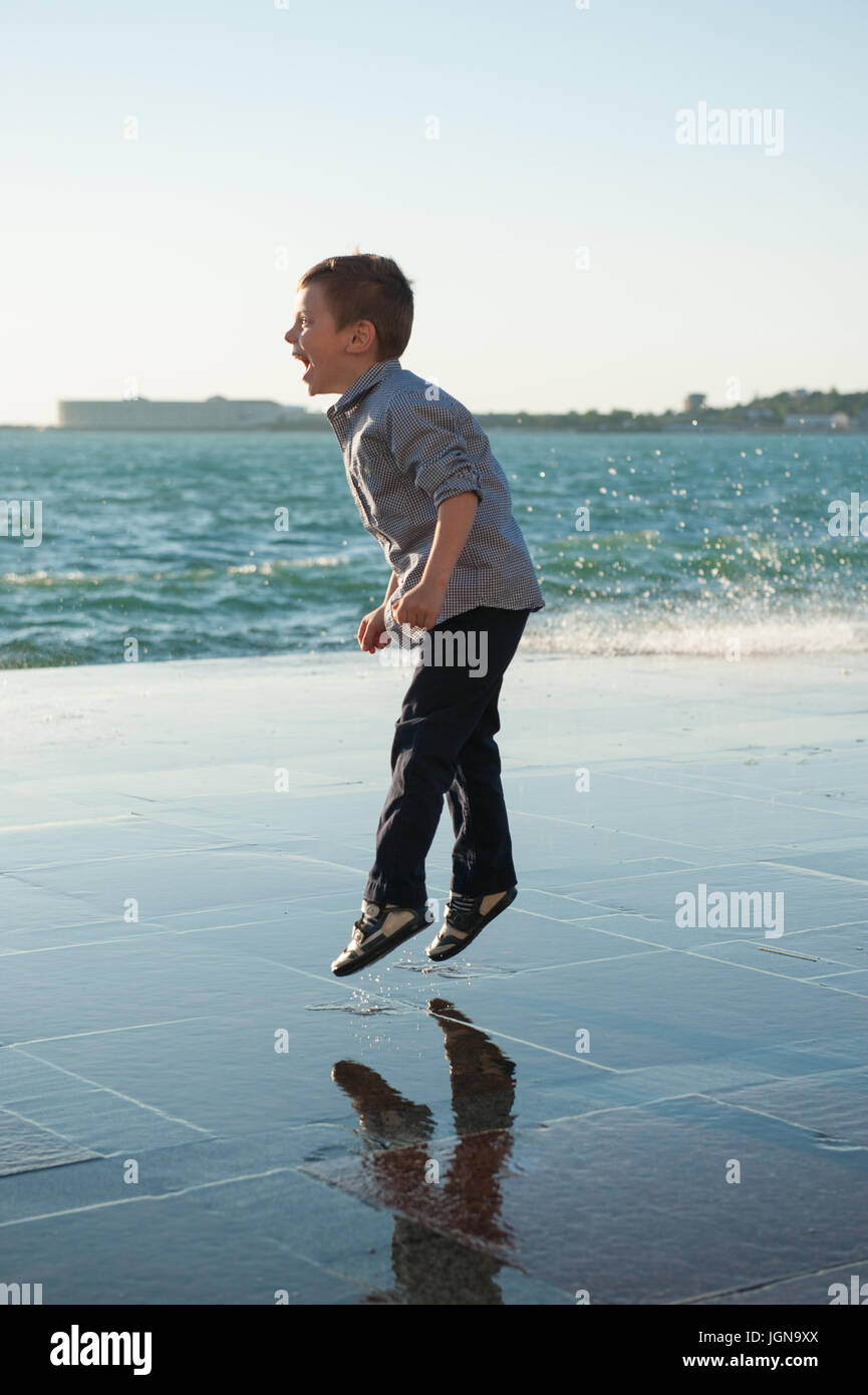Saut de rire petit garçon dans l'arrière-plan d'une tempête sur la mer ...