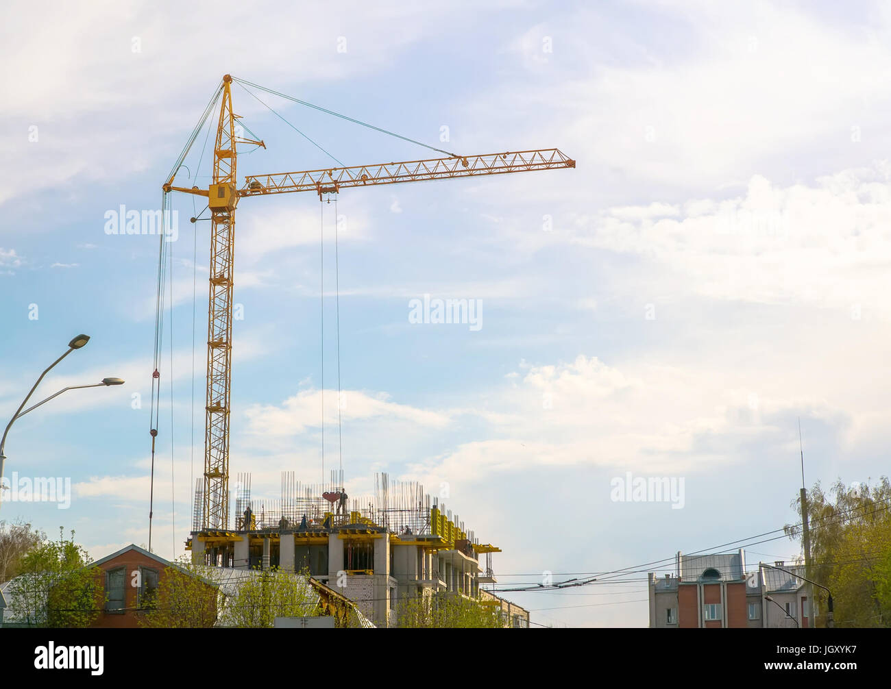 Grue jaune haut de la construction d'une maison dans le beau ciel bleu ...