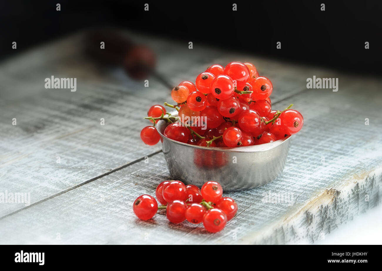 Fruits rouges groseilles rouges mûrs se situent sur une planche de bois ...