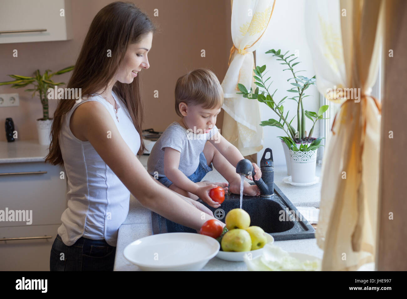 Fils maman cuisine laver les fruits et légumes Photo Stock - Alamy