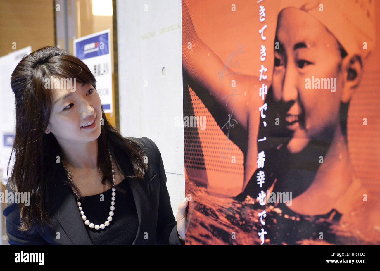 Ancien nageur Japonais Kyoko Iwasaki regarde une affiche montrant sa ...