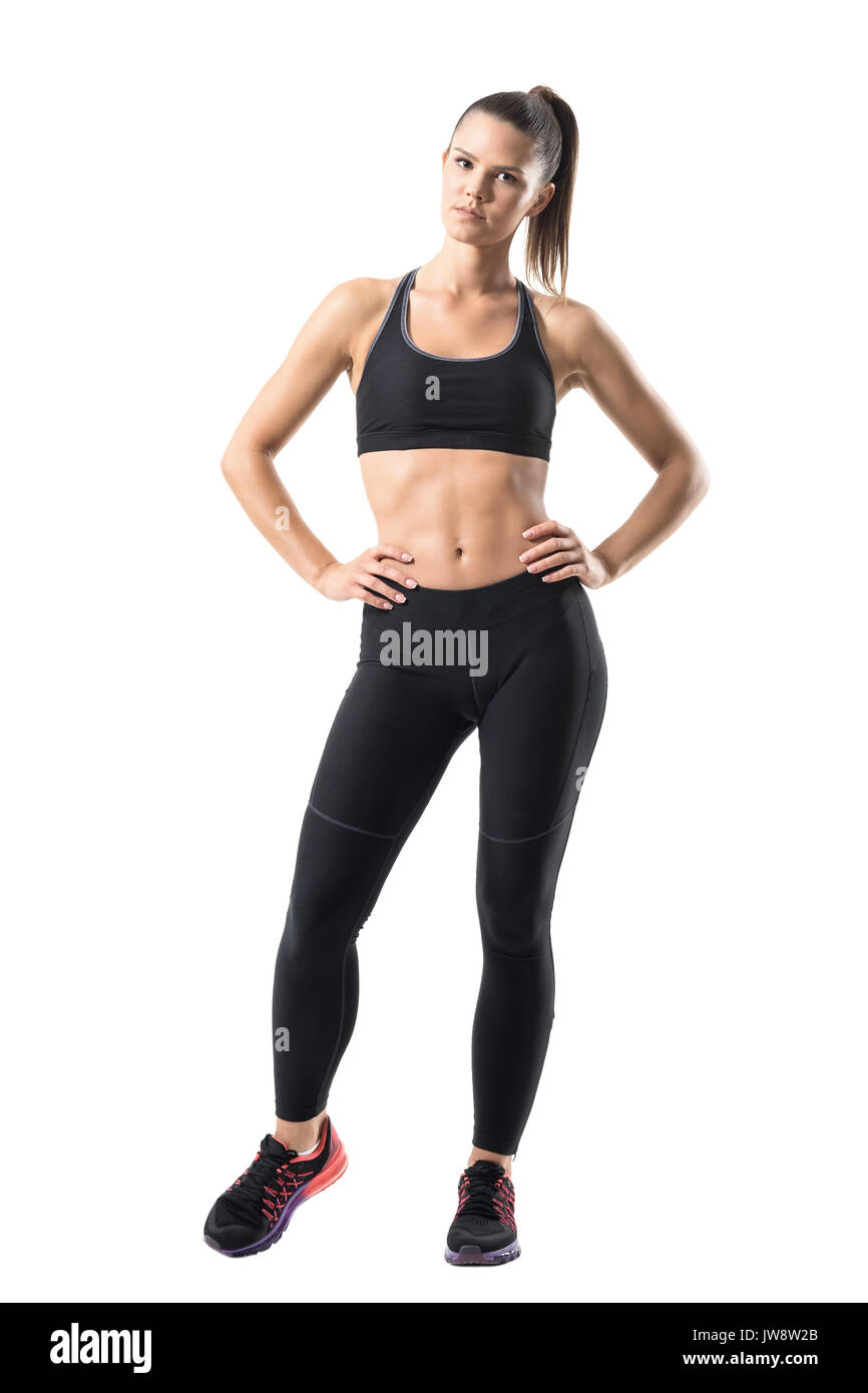 Jeune jolie femme Fitness guêtres noires en haut du réservoir et posant ...