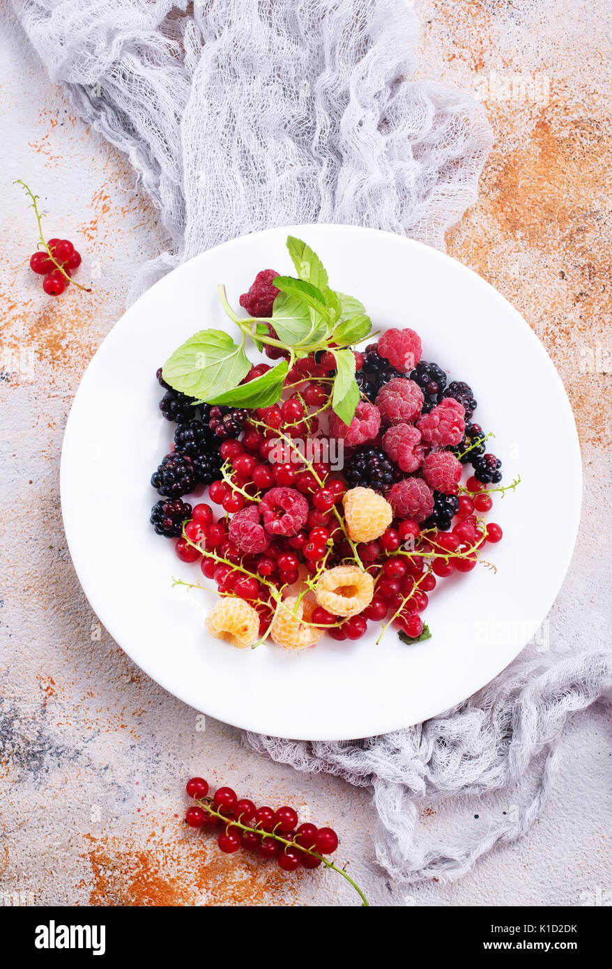 Mélanger les petits fruits sur une assiette et sur une table Photo ...