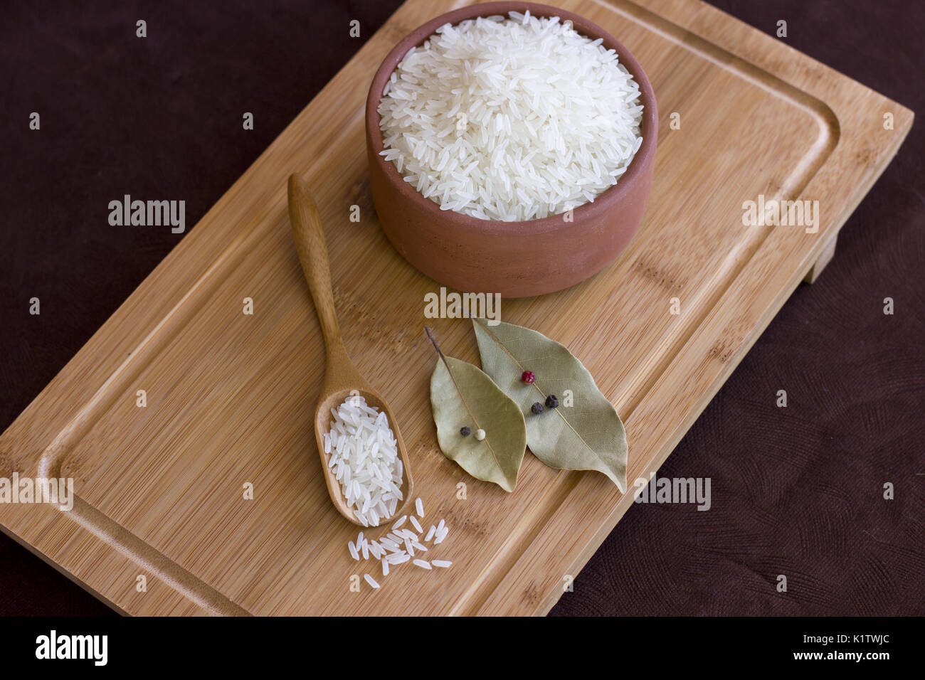 Le riz blanc dans un bol d'argile et de la cuillère en bois. Les ...