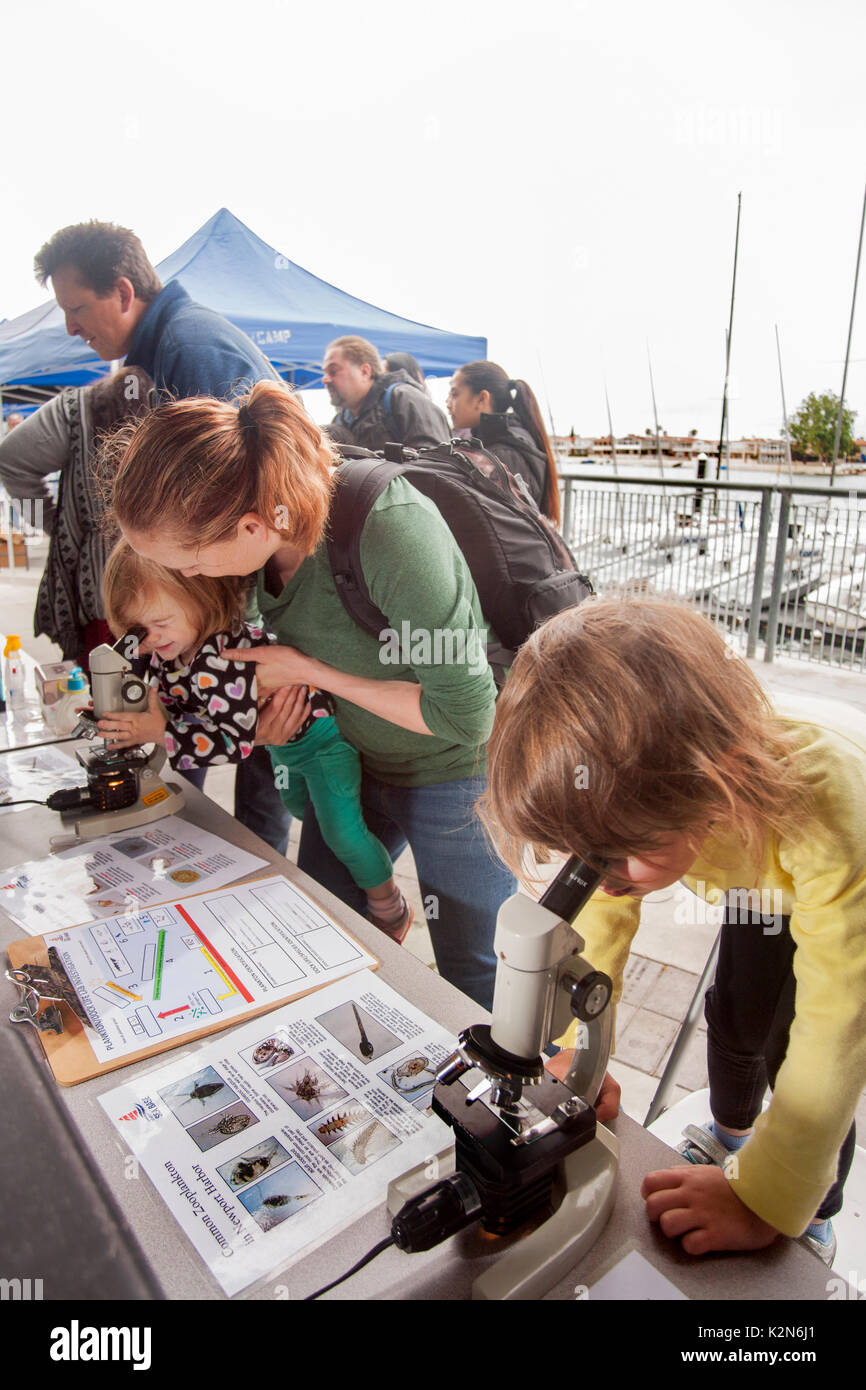 Une mère et ses deux filles regarder au microscope à des exemples de ...