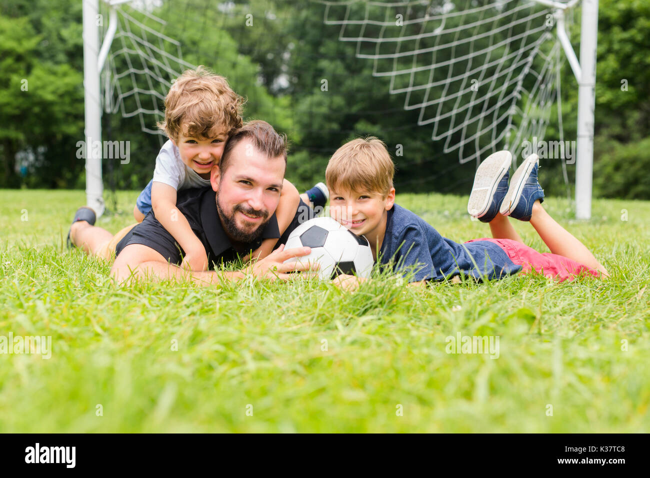 Le père avec son fils à jouer au football sur un terrain de football Photo Stock - Alamy