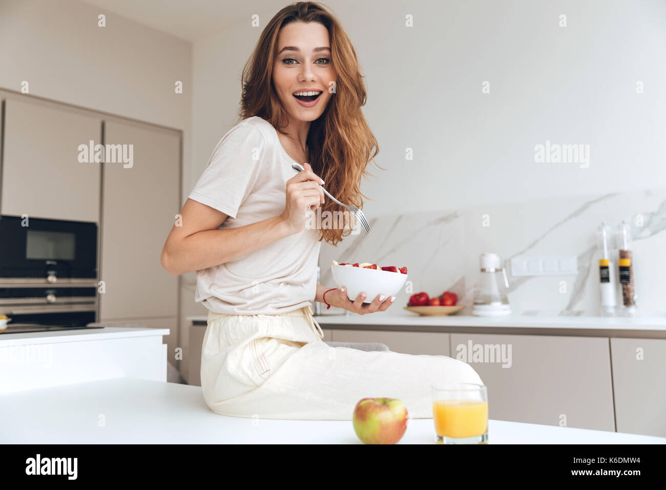 Jolie femme à la caméra et prendre le petit déjeuner alors qu'il était ...