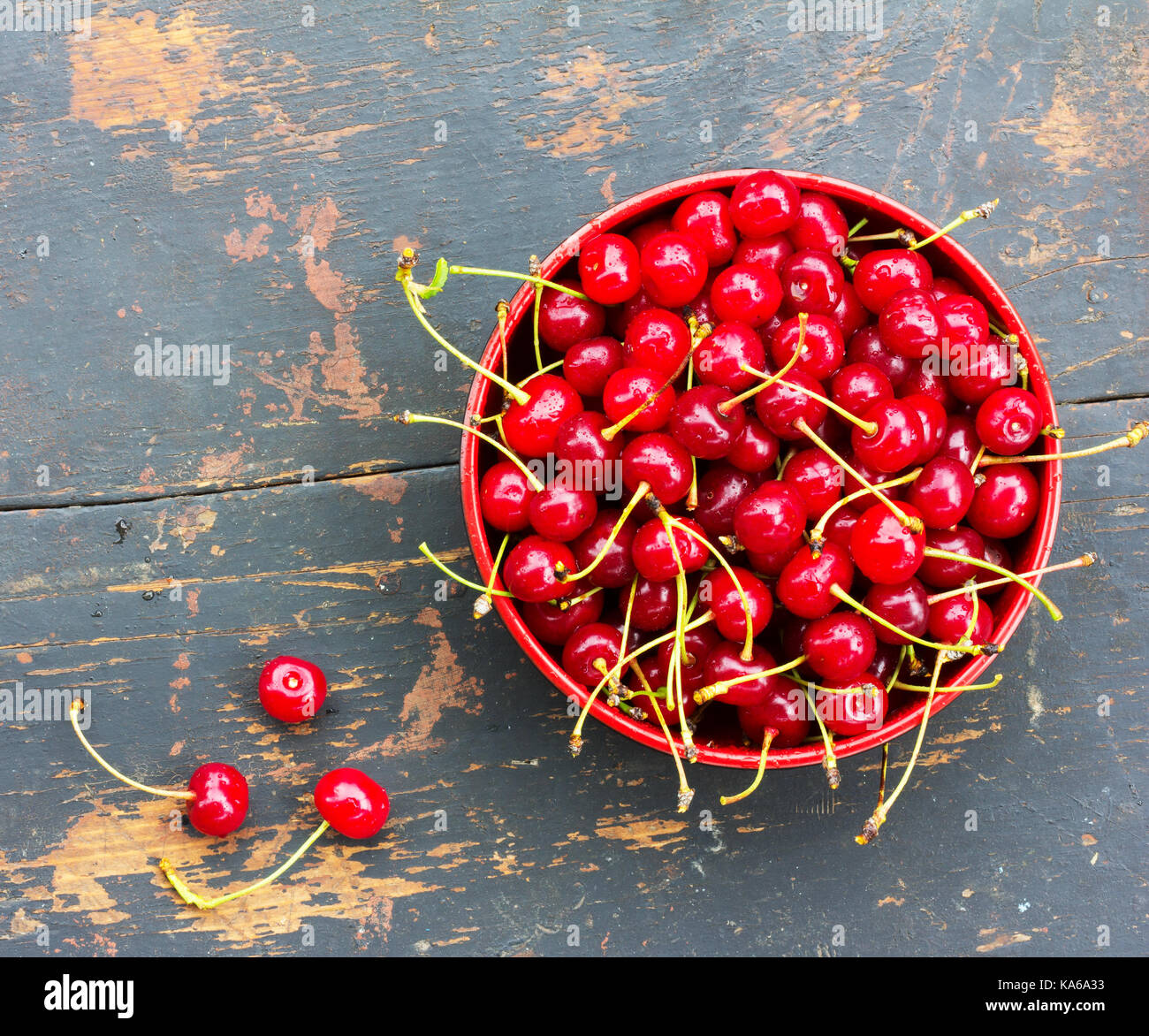 Avec des queues de cerises mûres rouges dans une plaque circulaire sur ...