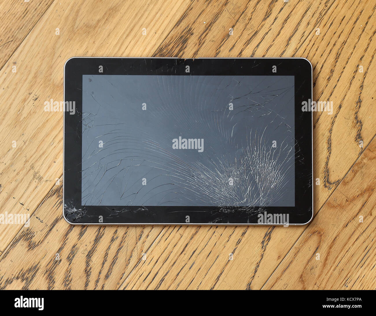 Tablette ordinateur posé sur un plancher en bois avec affichage détruit ...