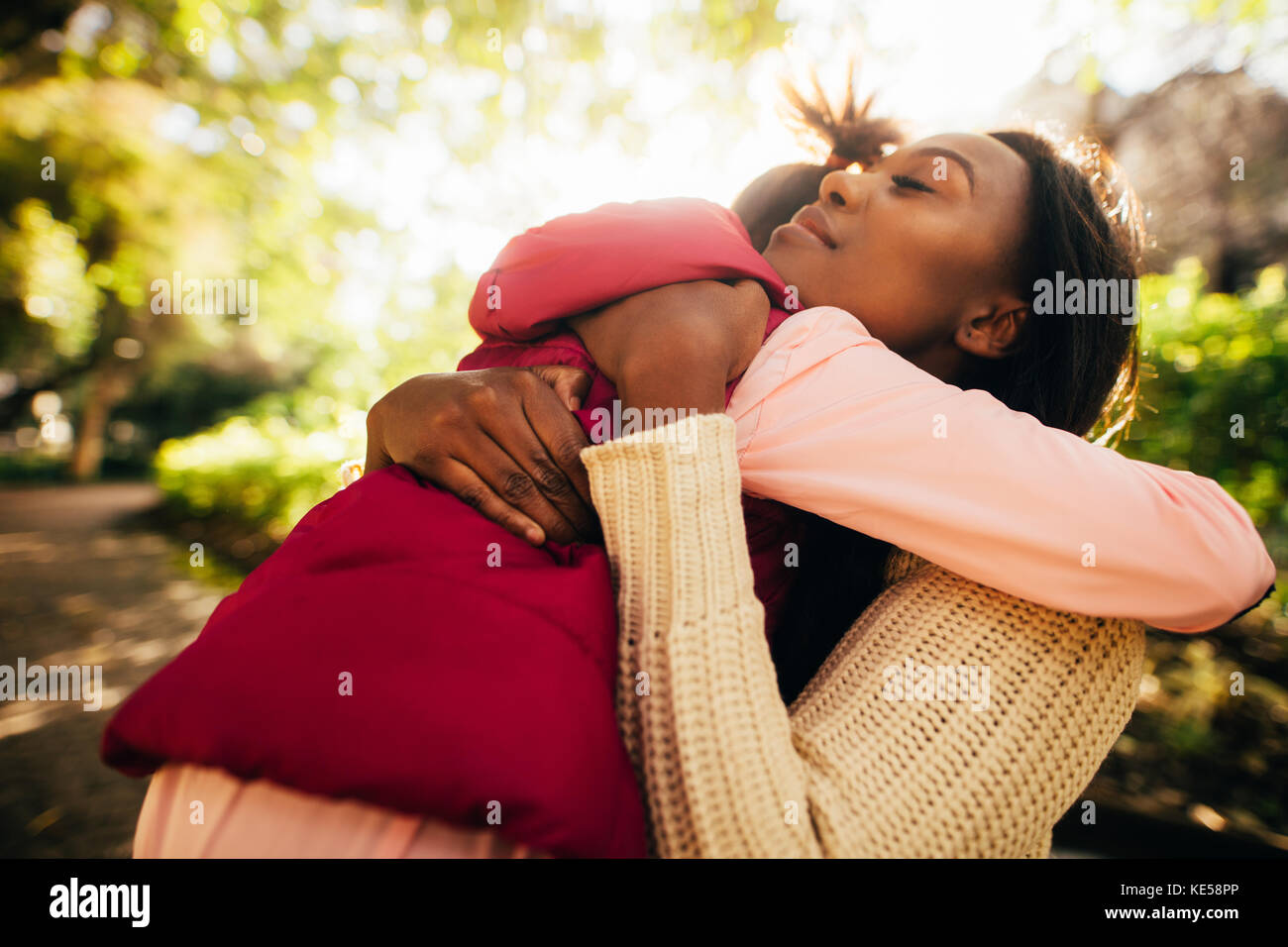 Jeune femme africaine embrasser sa petite fille dans le parc. Mère et ...