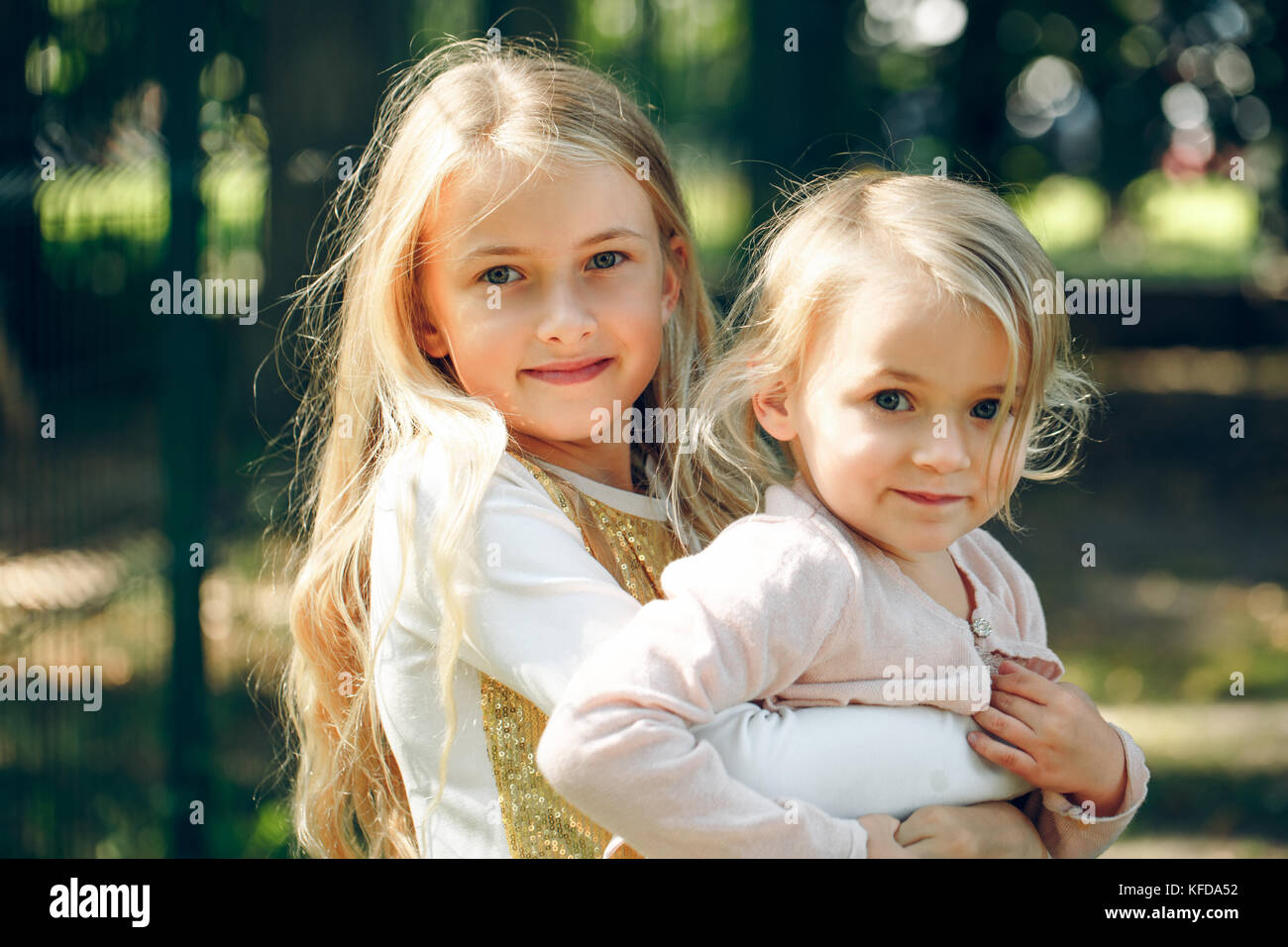 Lamour Doux De Deux Soeurs Les Filles Sembrassent Avec Sourires Et