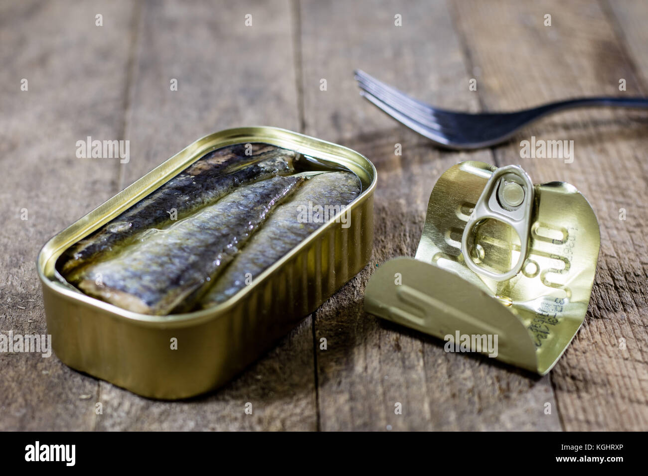 Une boîte de conserve de poisson sur une table de cuisine en bois. près ...