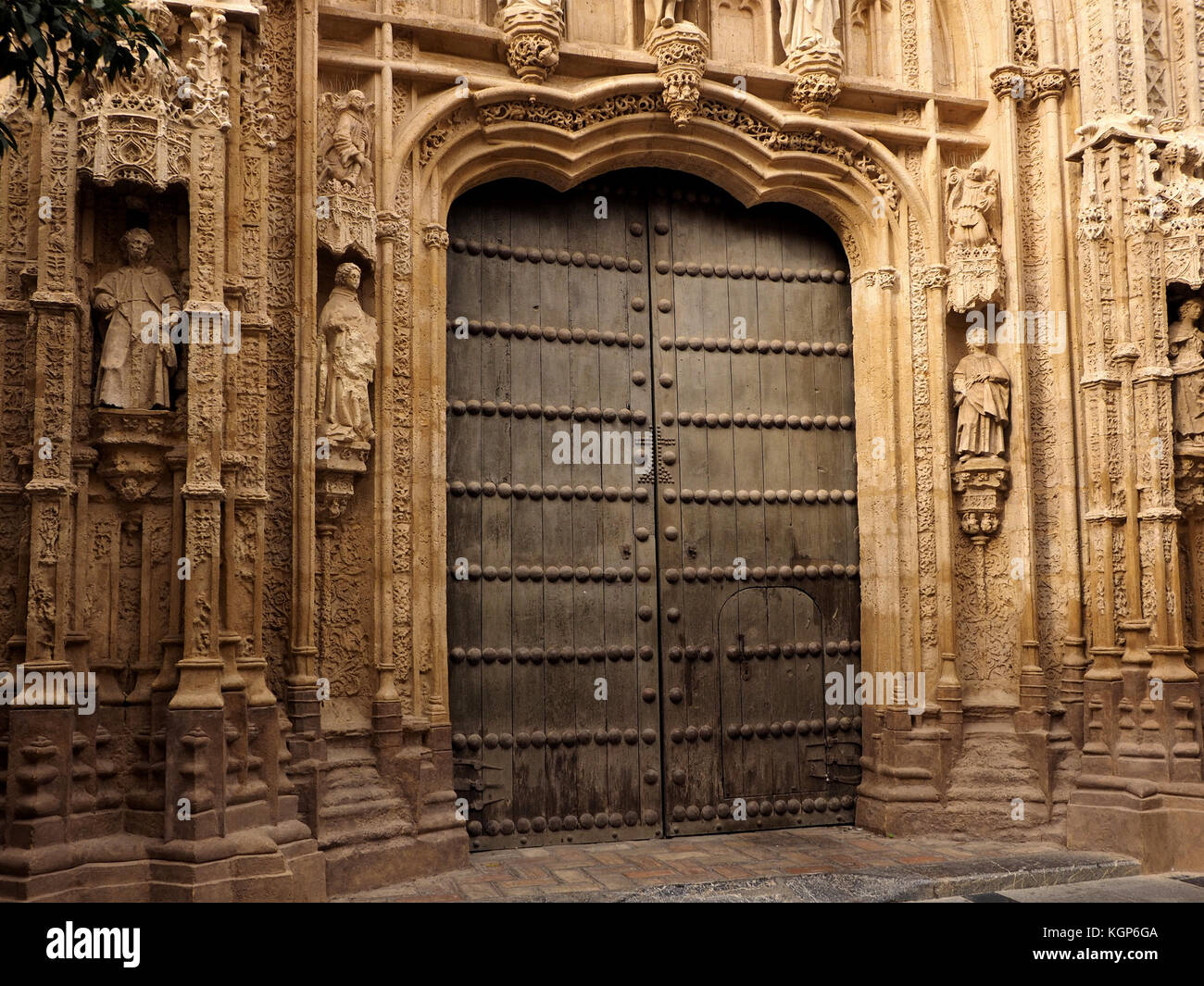 Double porte cloutée avec petite porte incrustée dans la pierre arche ...