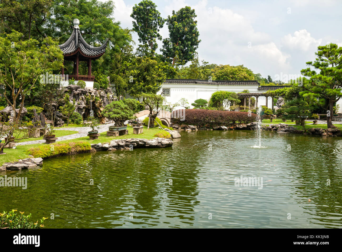 Bassin avec une fontaine et des poissons rouges dans le jardin chinois ...