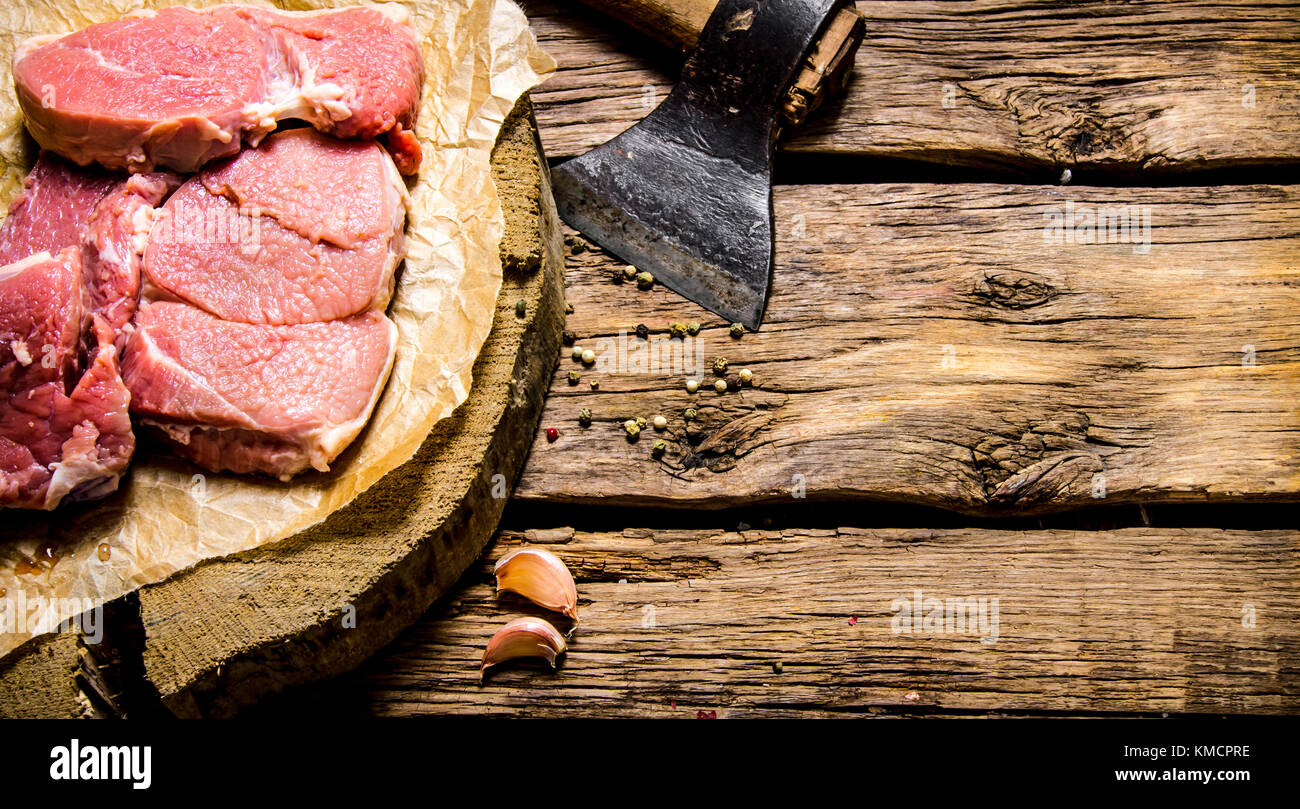 La viande hachée crue fraîche avec une hache. sur une table en bois. l ...