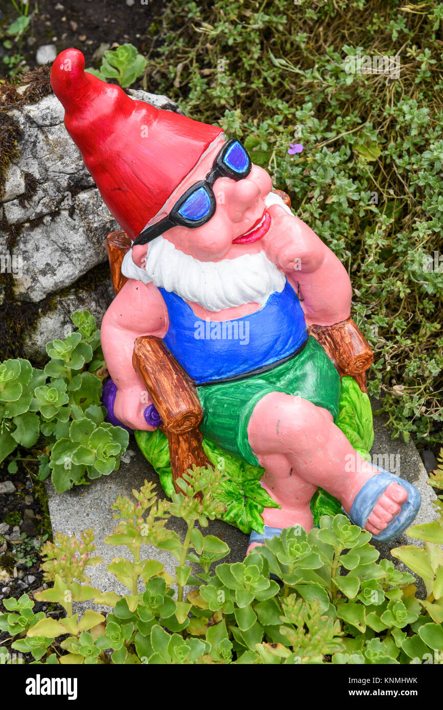 Nain de jardin assis sur une chaise sur un jardin d'une maison à ...