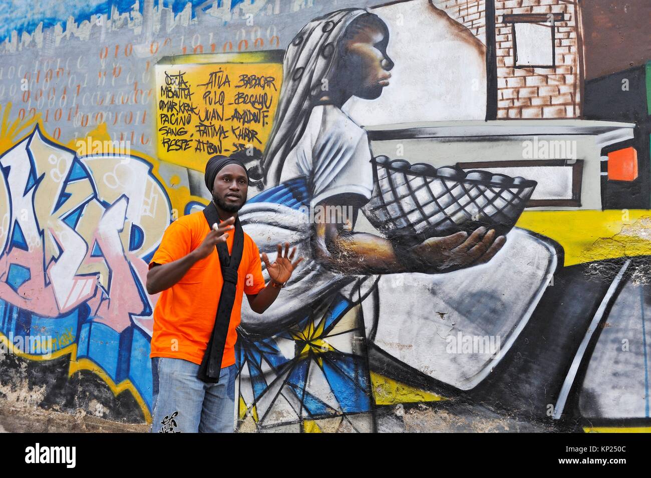 L'artiste graffiti sénégalais Docta à côté d'une murale collective dans ...