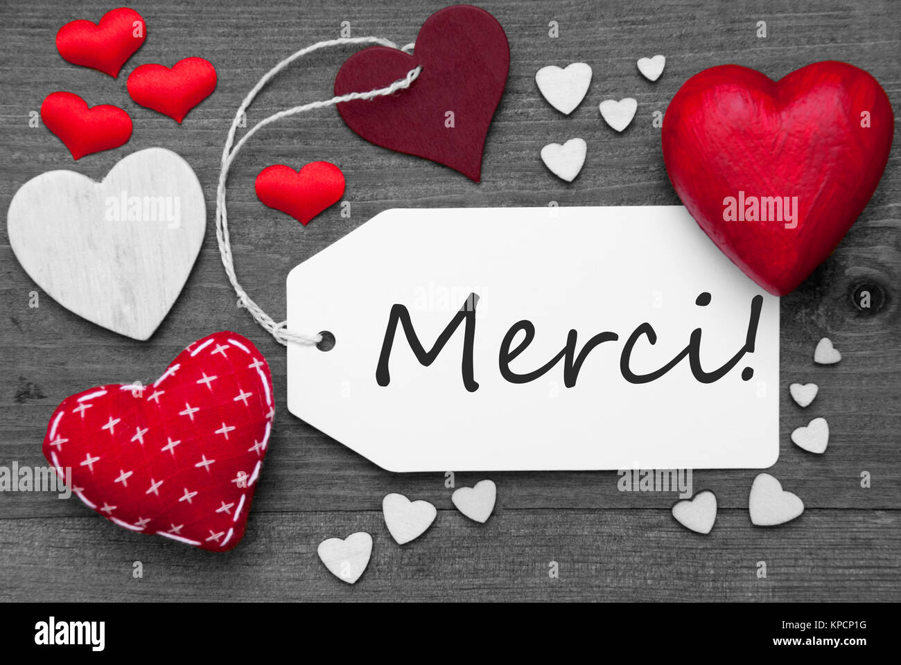 Avec étiquette Textile rouge coeurs en bois sur fond gris. Texte ...