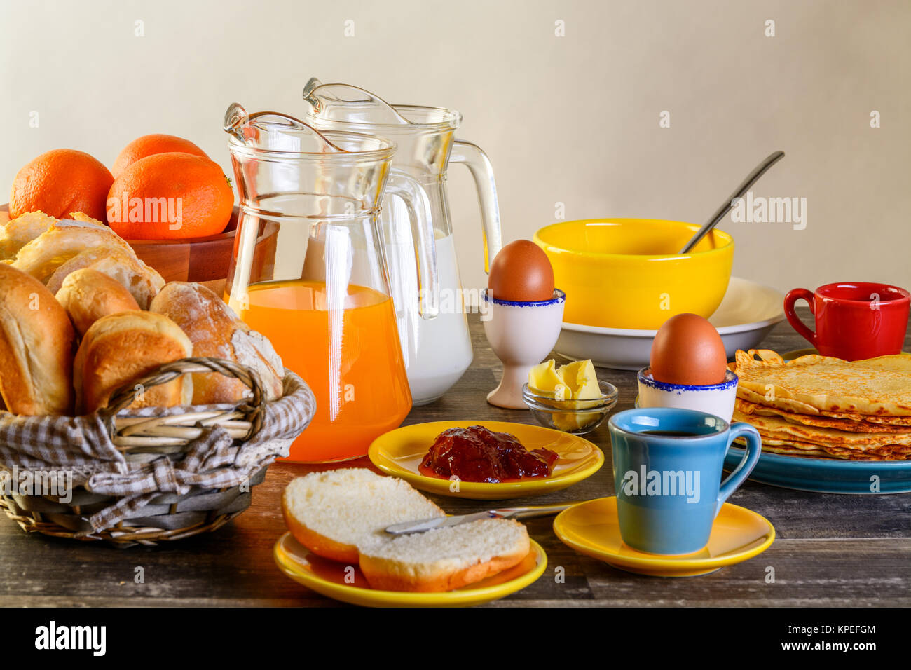 Le tableau d'ensemble complet de petit-déjeuner avec œufs, crêpes, pain, confiture, jus et plus ...