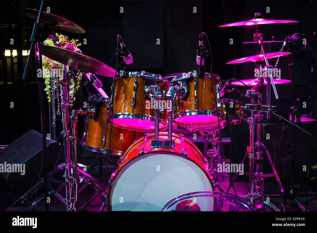 Un ensemble de batterie sur scène et magenta fond clair ; scène vide ...