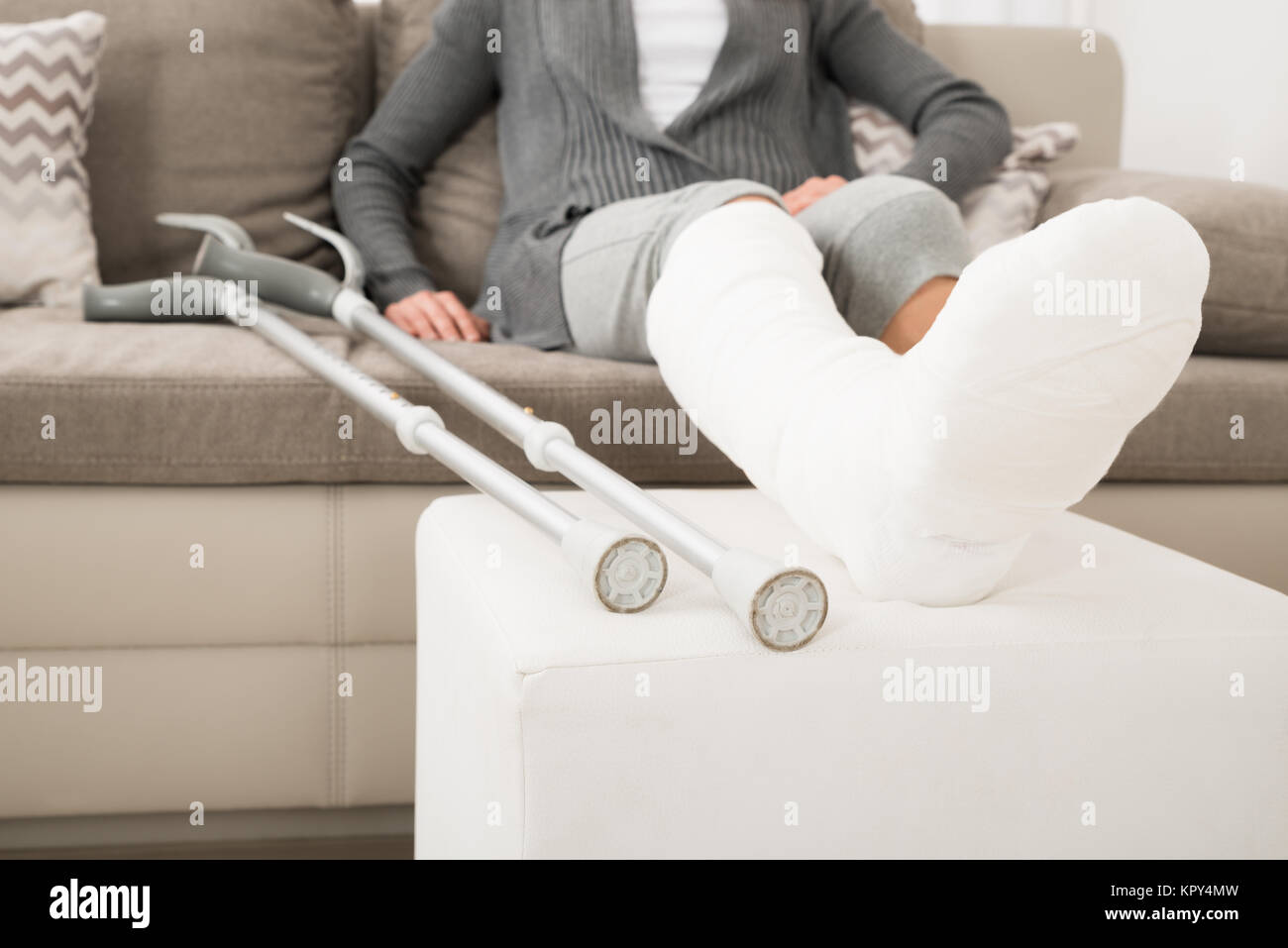 Femme avec la jambe plâtrée Sitting on Couch Photo Stock - Alamy
