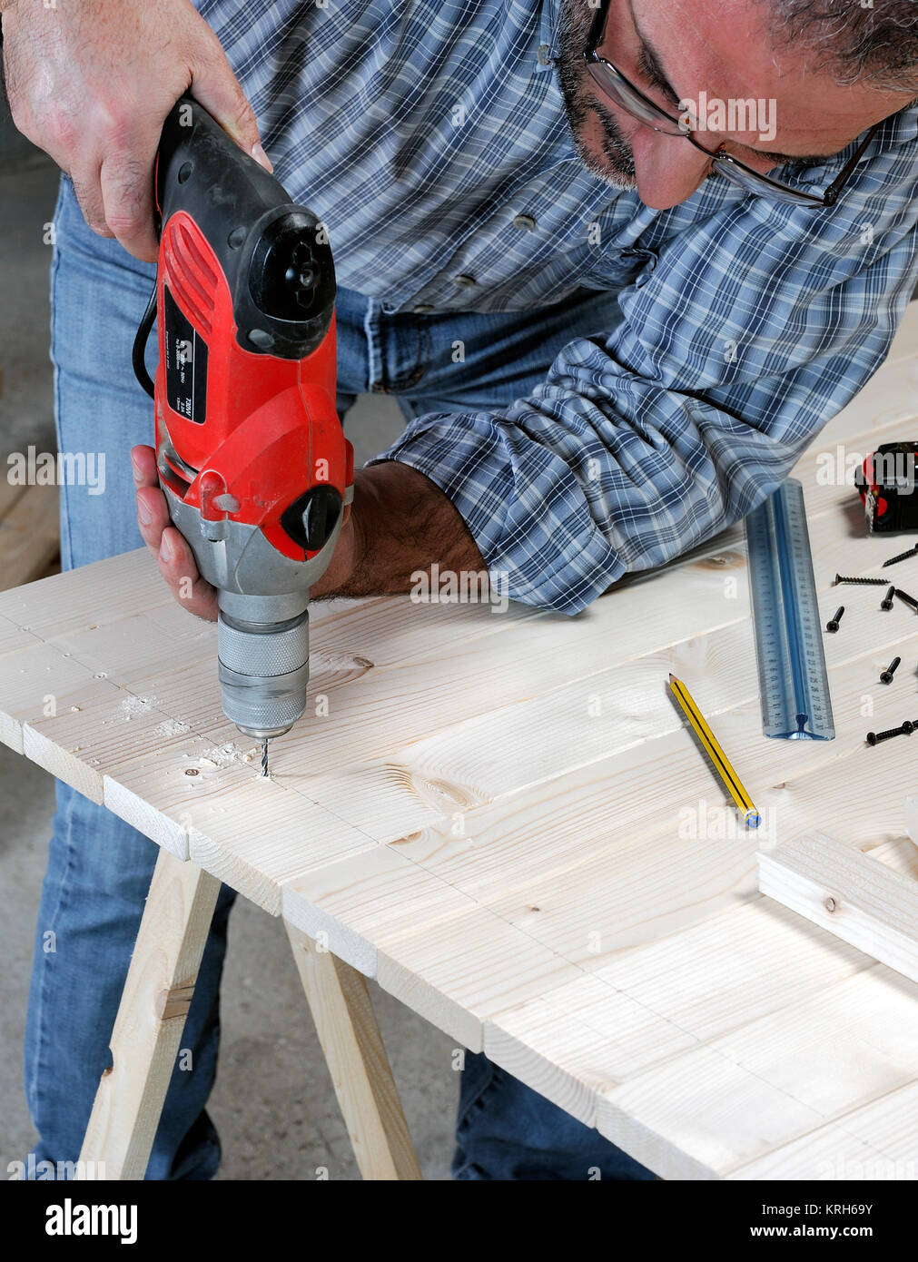 Artisan adultes percer les trous avec un panneau de bois pour réaliser ...