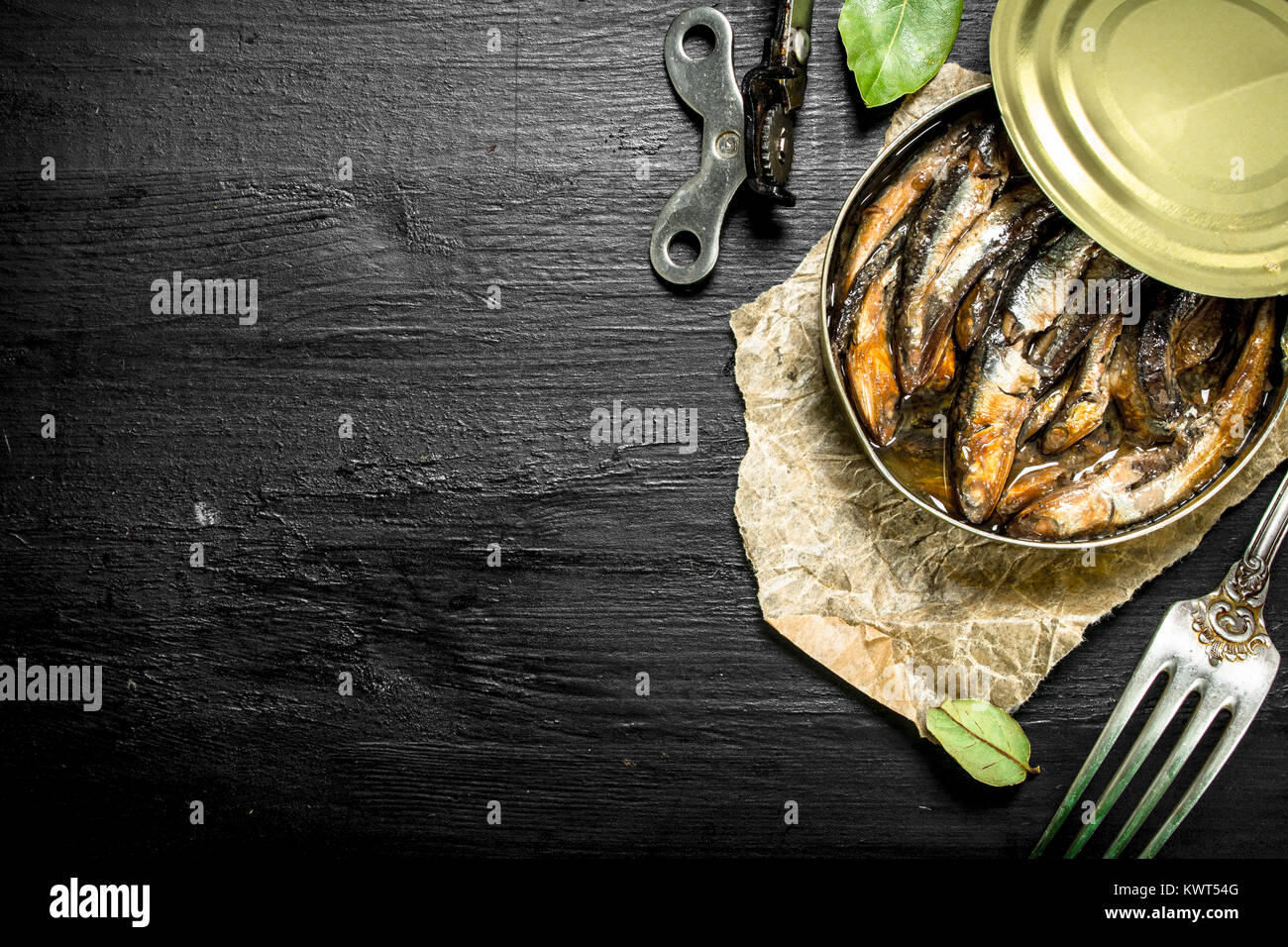 Anchois en conserve dans une boîte en fer-blanc. Sur le tableau noir ...