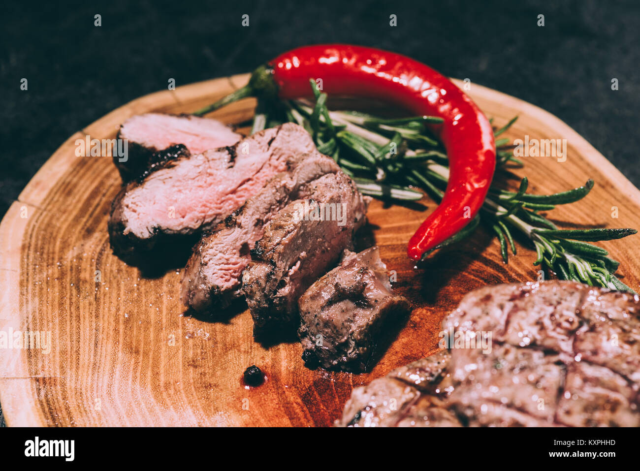 Vue rapprochée de tranches de viande grillée au romarin et de piment ...