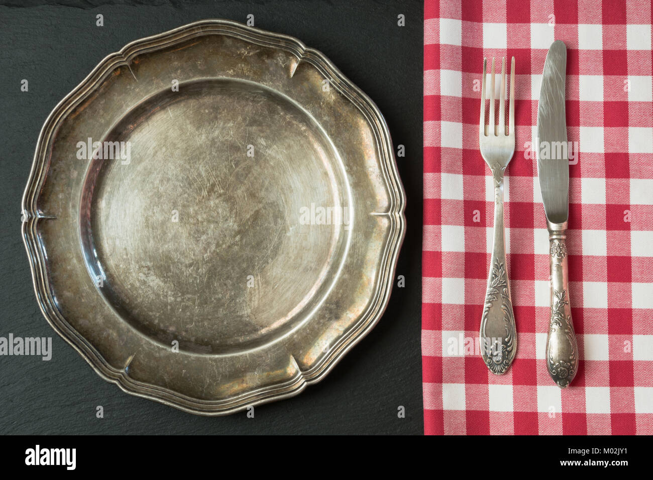 Plat de métal vide avec fourchette et couteau sur fond ardoise, avec l ...