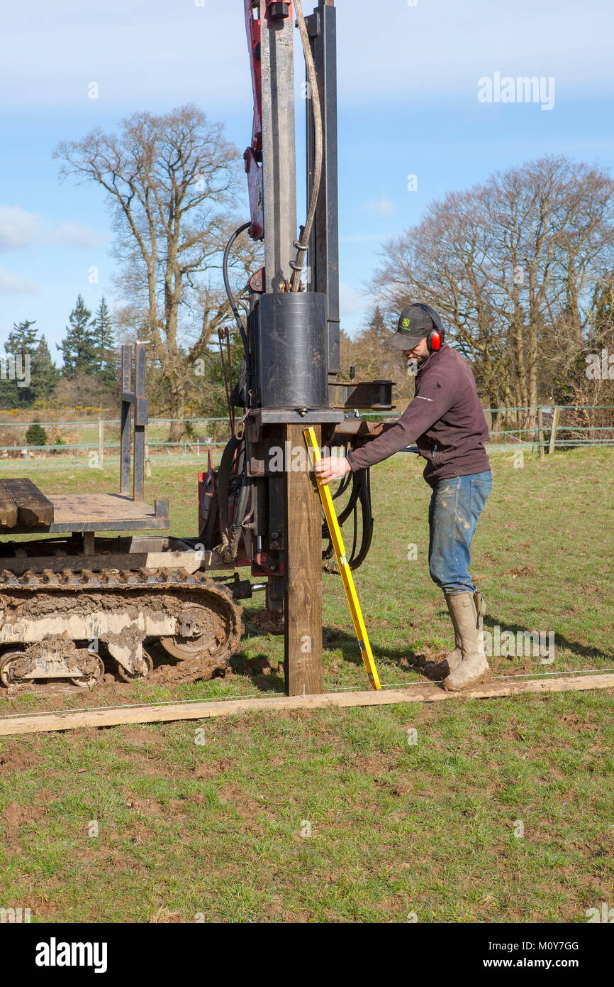 L'homme à l'aide d'une machine à l'éperonnage post drive new poteaux de ...