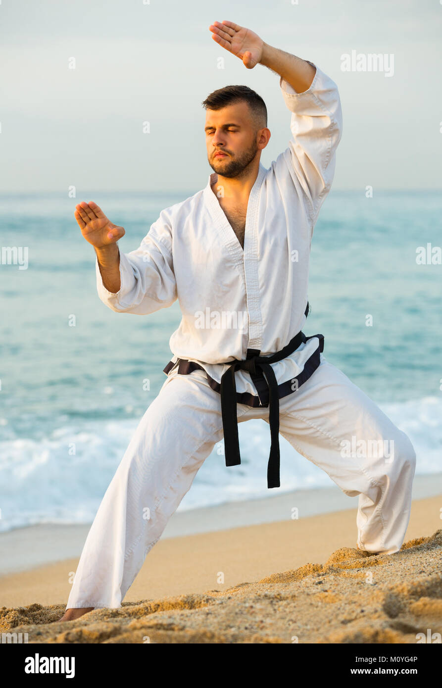 L'homme est l'exercice à faire le Shiko-dachi position sur la plage ...
