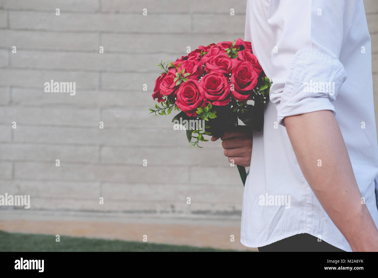 Man holding bouquet de roses rouges dans le dos. copain copine surprise ...