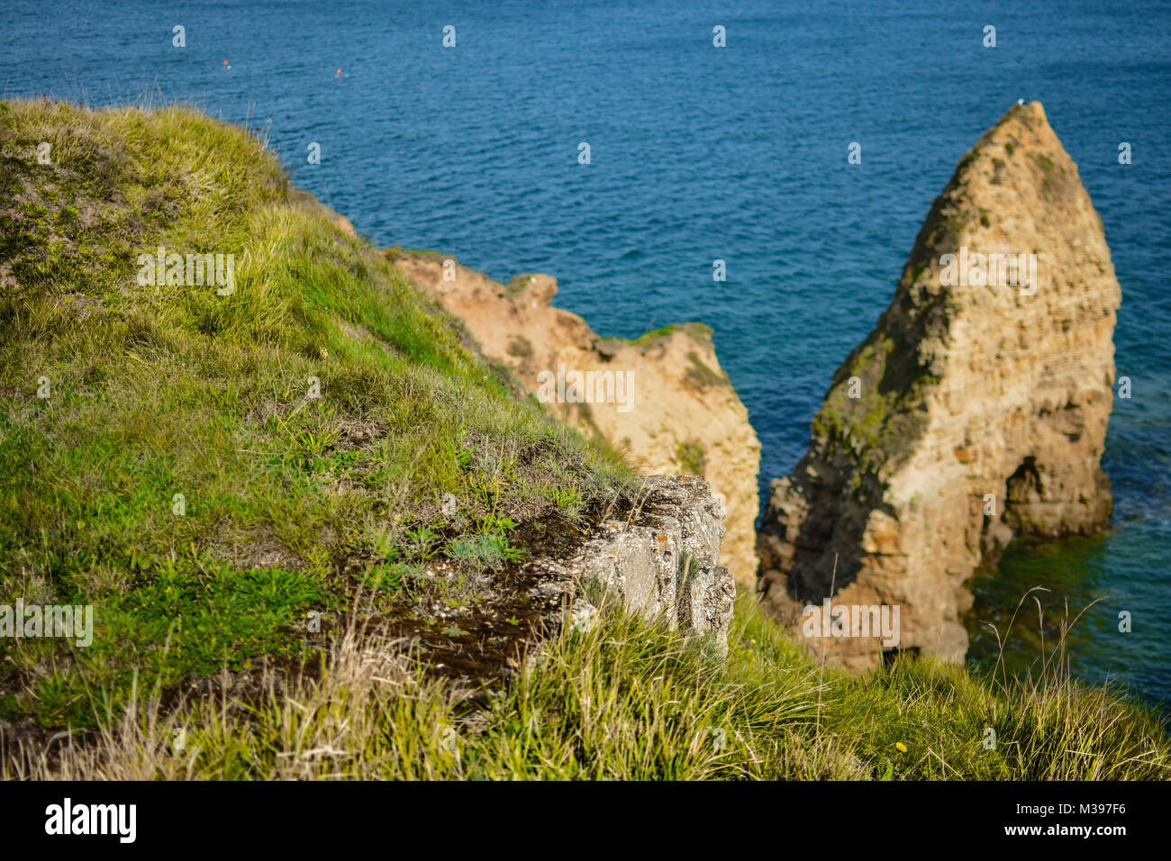 Une corniche surplombant les falaises de la Pointe du Hoc avec la côte ...