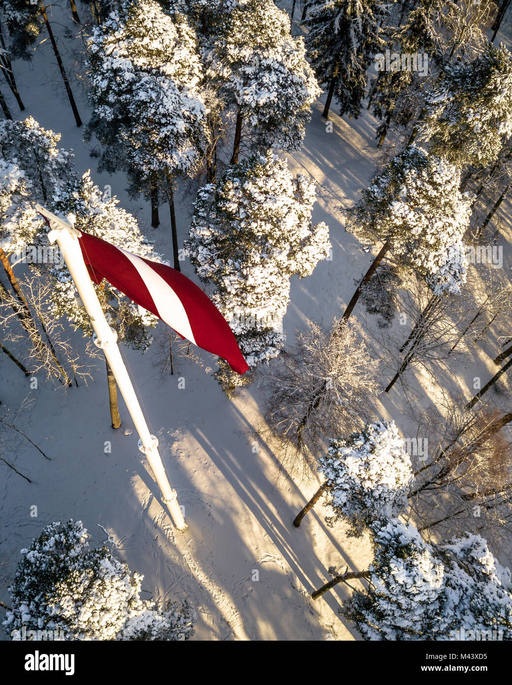 Photographie aérienne du drapeau letton élevée jusqu'au poteau dans ...