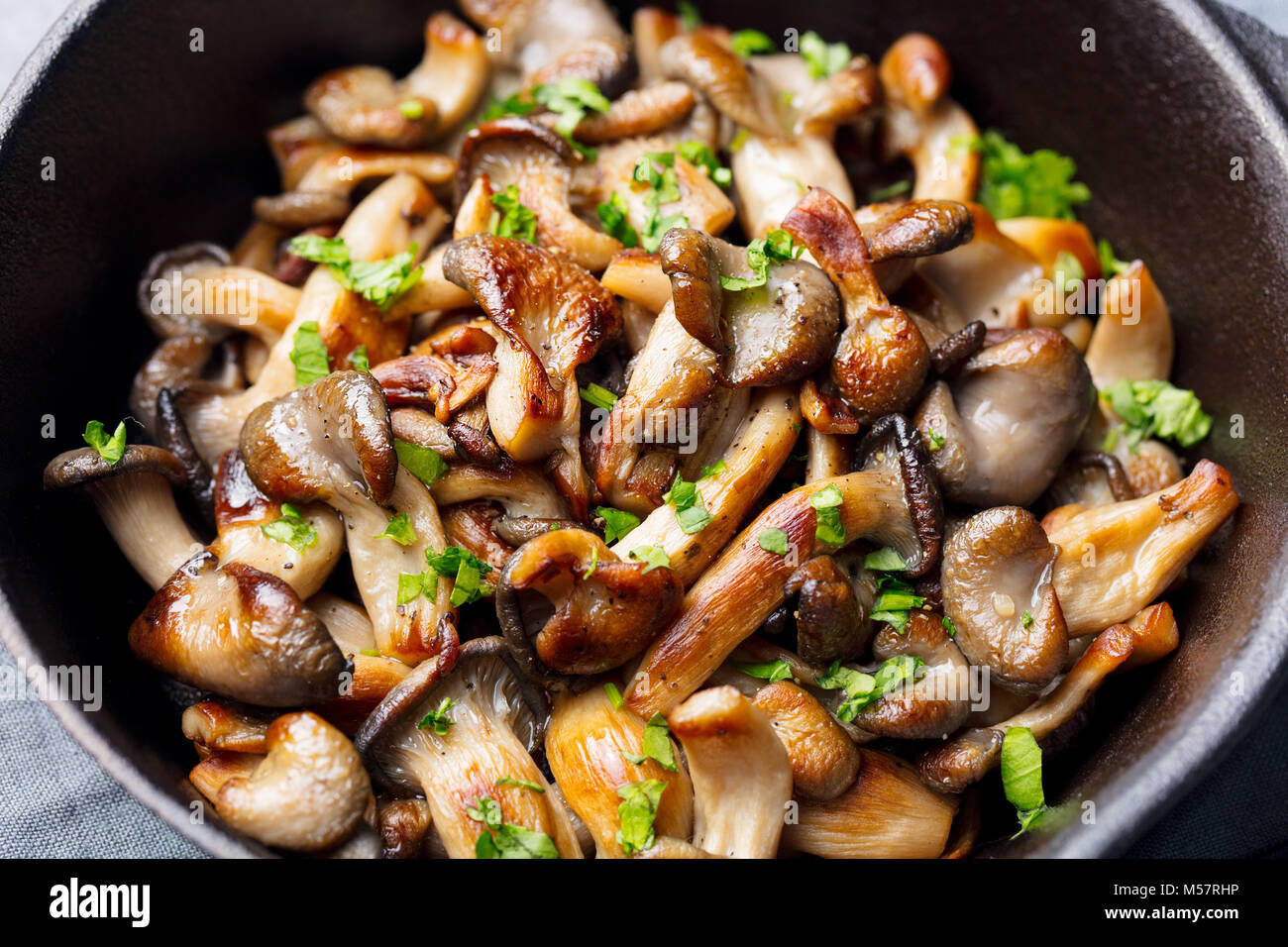 Poêlée de champignons à l'aide de fines herbes dans la poêle en fonte ...