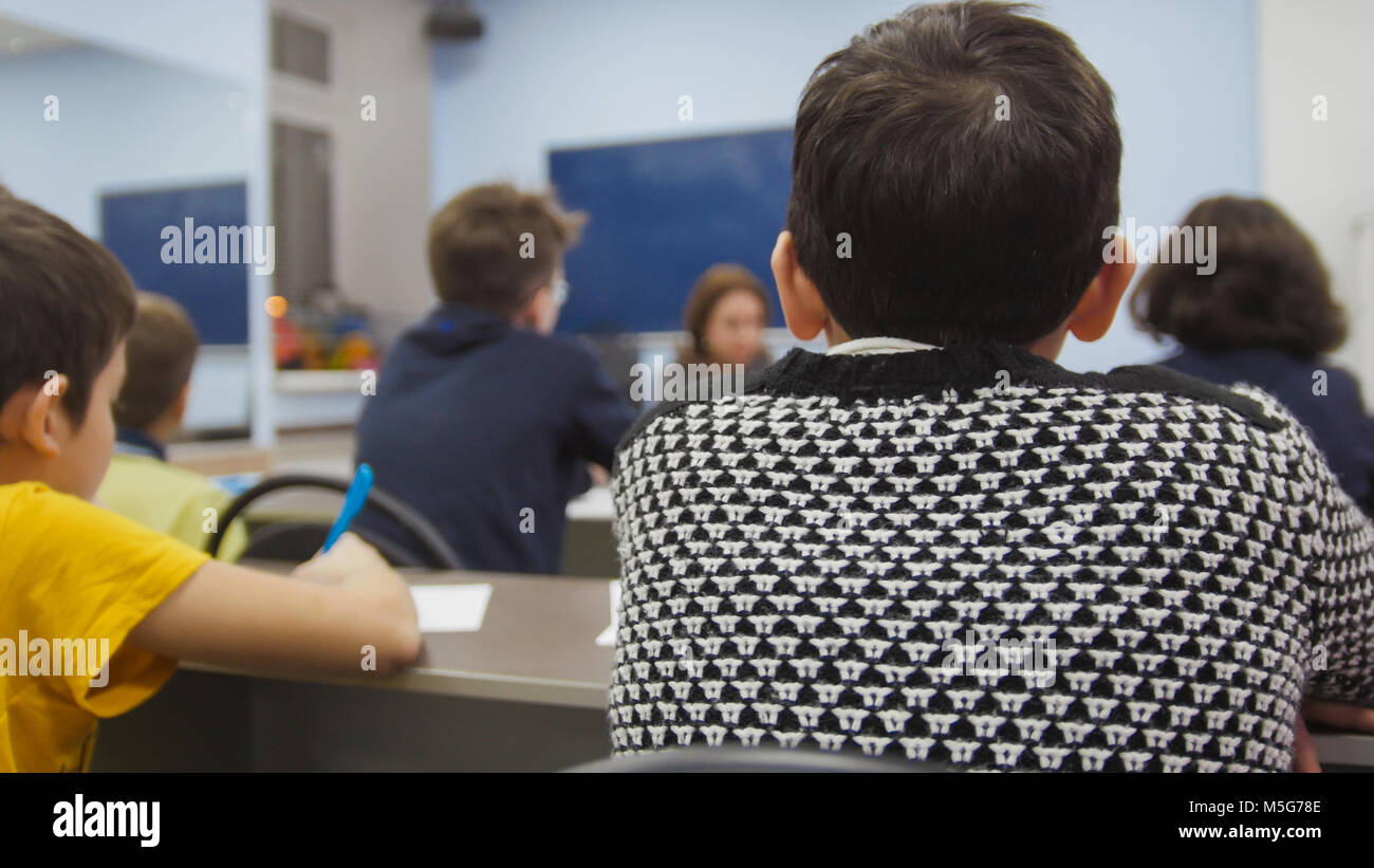 Camarades de classe des enfants à l'école - garçon est assis à la table ...