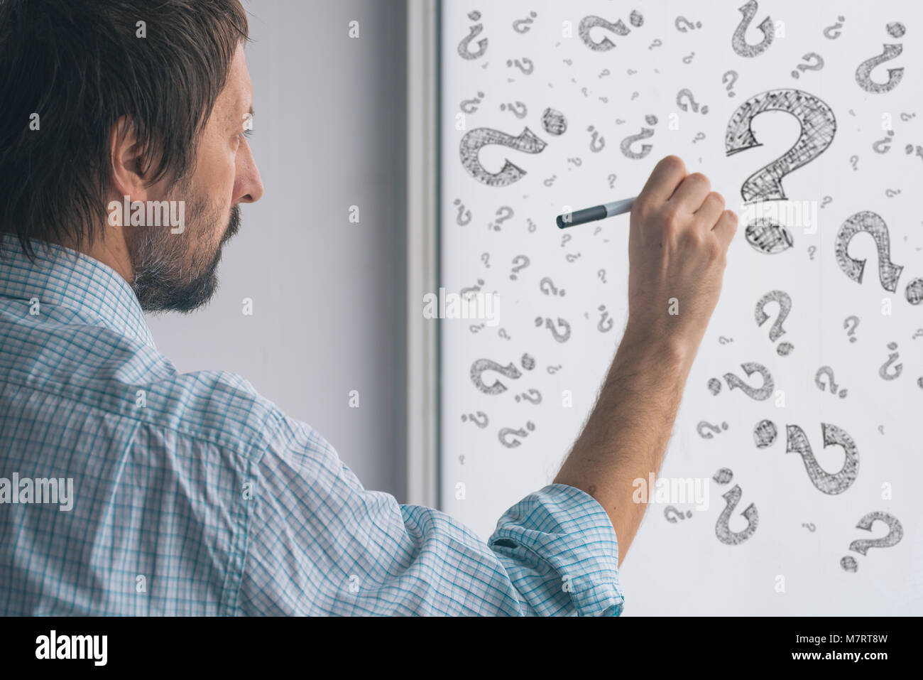 Homme d'interrogation perplexe dessin sur le tableau blanc dans le ...