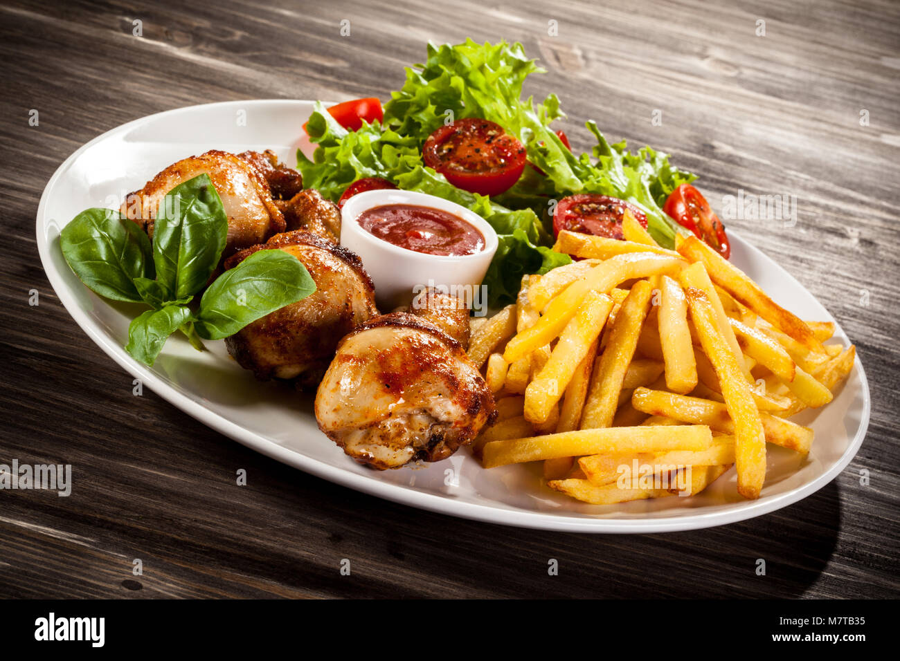 Cuisses de poulet rôti avec des frites et des légumes Photo Stock - Alamy
