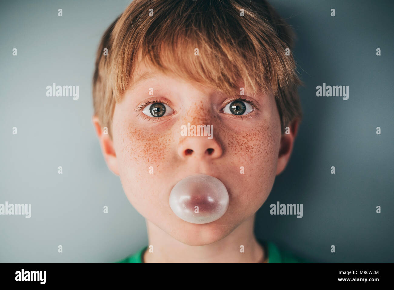 Portrait d'un garçon avec des taches de rousseur qui souffle dans un ...