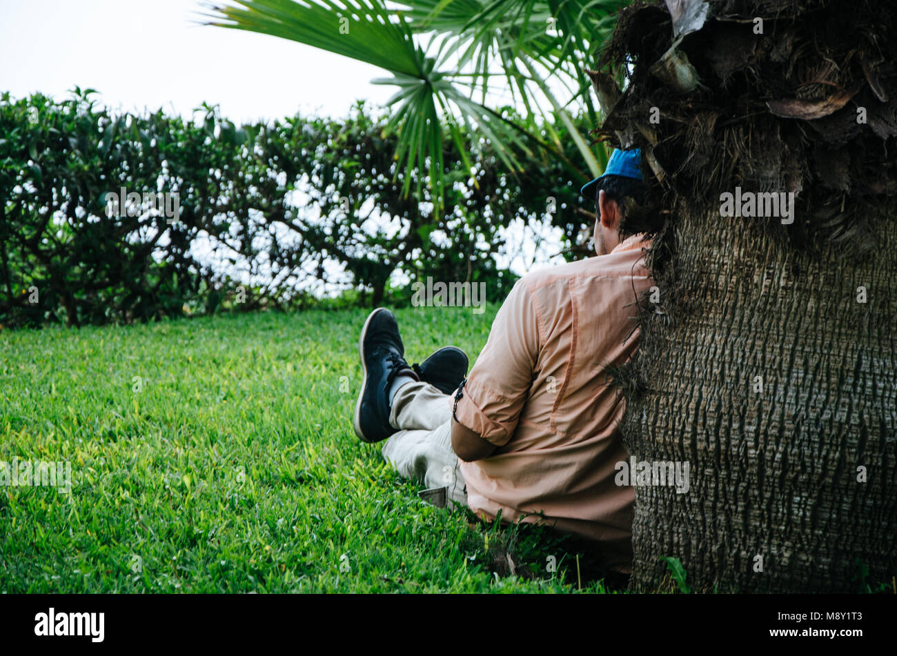 L'homme posé sur le tronc d'un arbre Photo Stock - Alamy