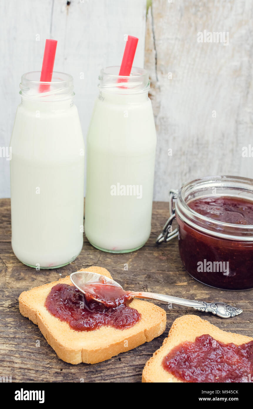 Toasts avec de la confiture de fraise et le lait pour le petit déjeuner le rusric fond de bois ...