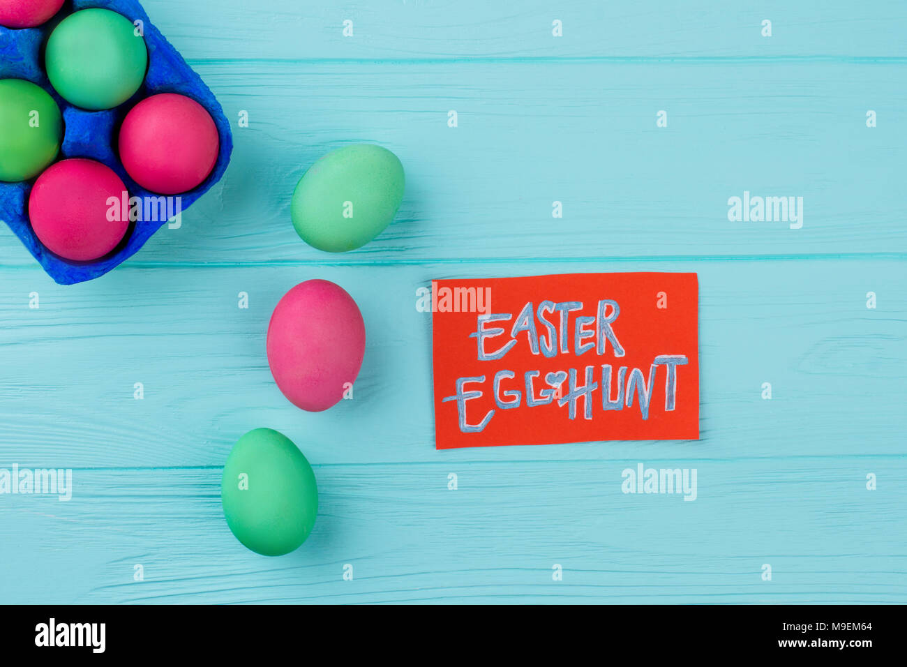 Les oeufs de Pâques colorés sur fond de bois. Carte de papier rouge ...