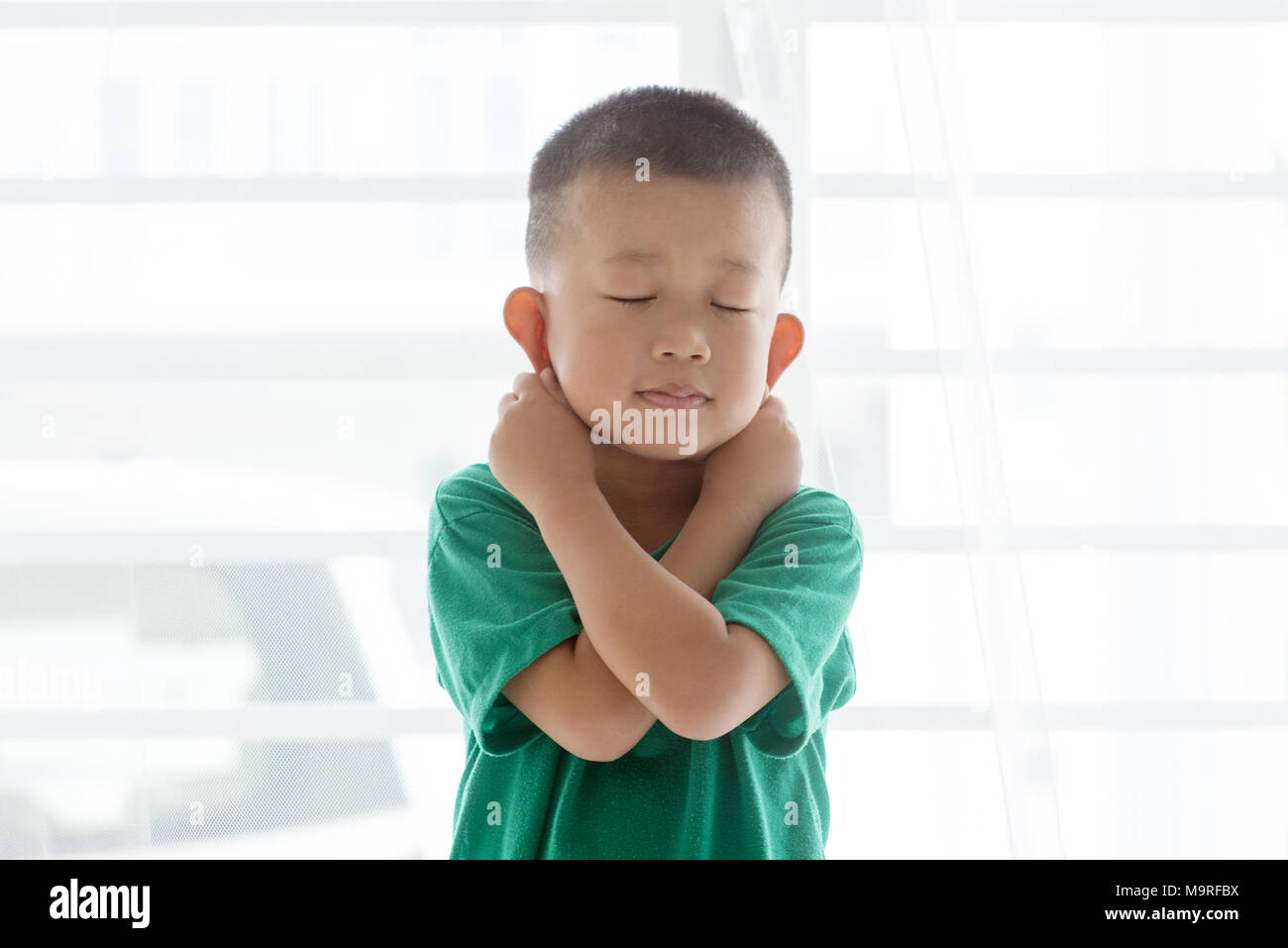 Jeune enfant à la maison. Asian boy ludique obtenir puni en tirant les ...