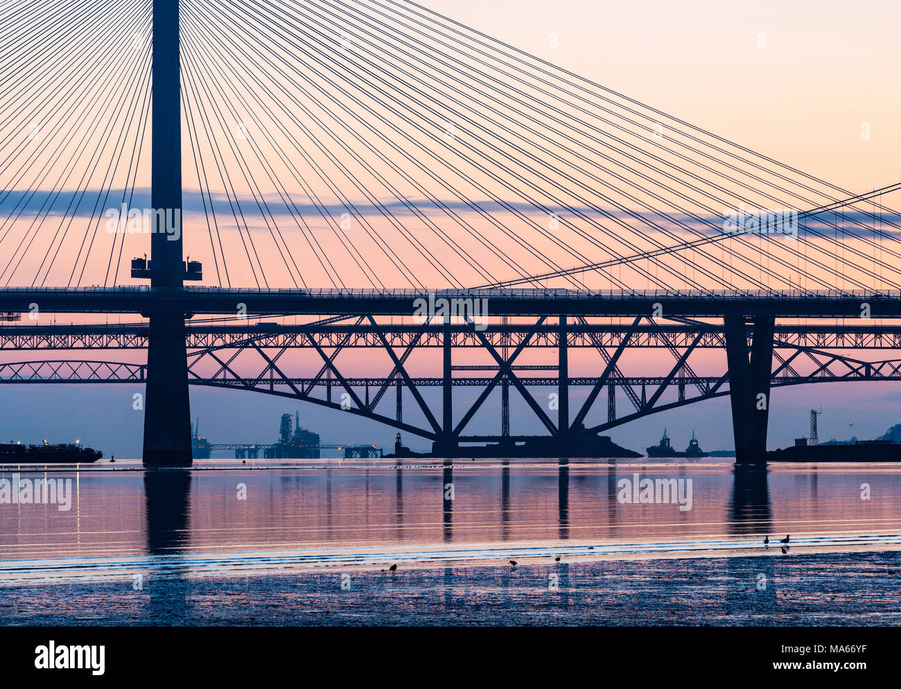 Lever du soleil sur les trois grands ponts traversant l'estuaire de la Forth à South Queensferry ...