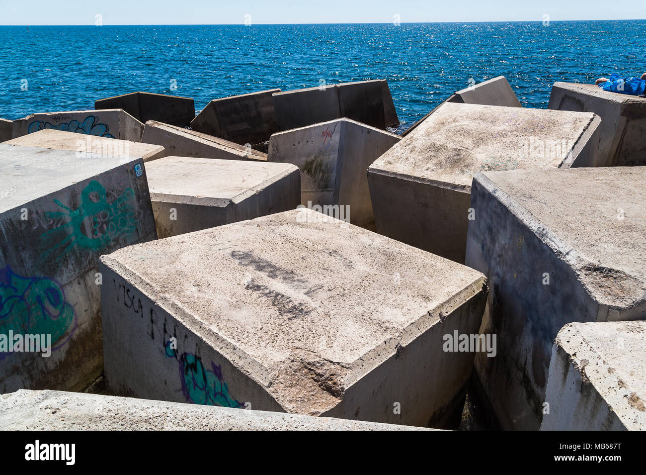 Blocs cubes de béton forment un brise-lames sur la plage de Nova Icaria ...