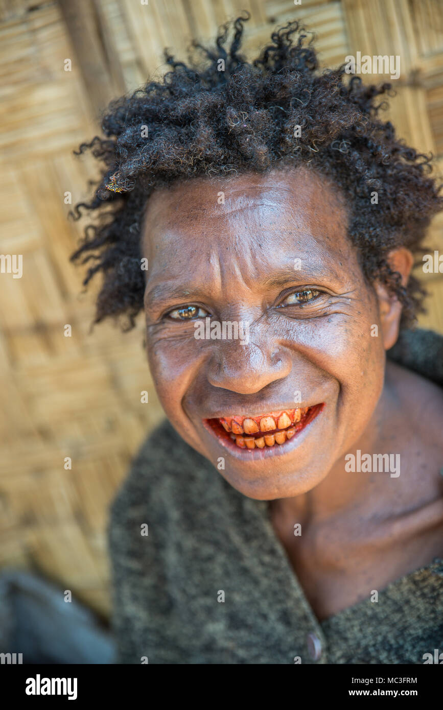 Une femme Papou avec dents rougeâtres causés par la noix de bétel ...