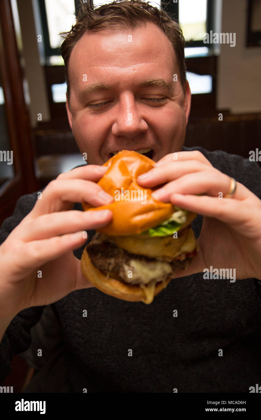 Man eating huge burger Banque de photographies et d’images à haute ...